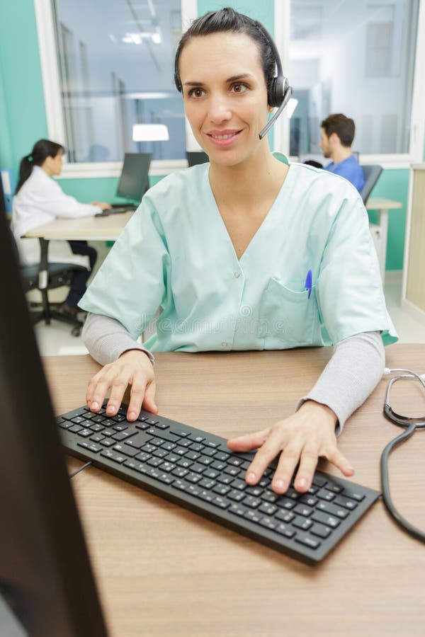 Female Nurse Working on Computer at Hospital Reception Stock Image ...