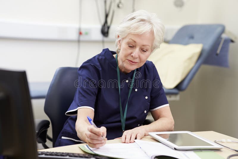 Female Nurse Working at Desk in Office Stock Photo - Image of illness ...