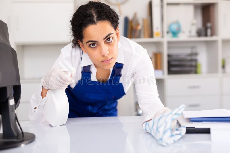 Female Office Cleaner is Cleaning Dust from the Desk in Office Stock ...