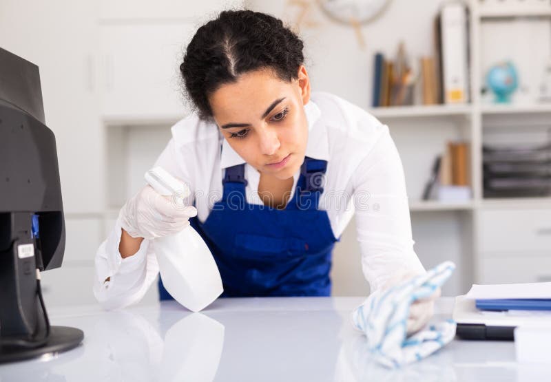 Female Office Cleaner is Cleaning Dust from the Desk in Office Stock ...