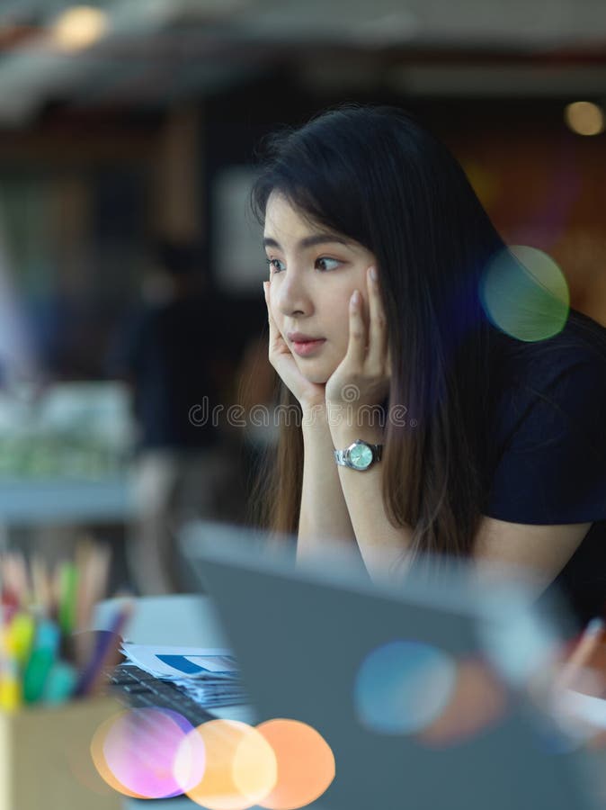 Female Office Worker Hands To Cheek while Thinking about Her Work in ...