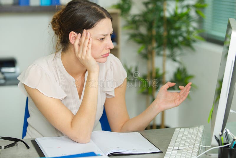 Female Office Worker Looking Confused while Looking at Computer Screen ... Female Office Worker Looking Confused while Looking at Computer Screen ...