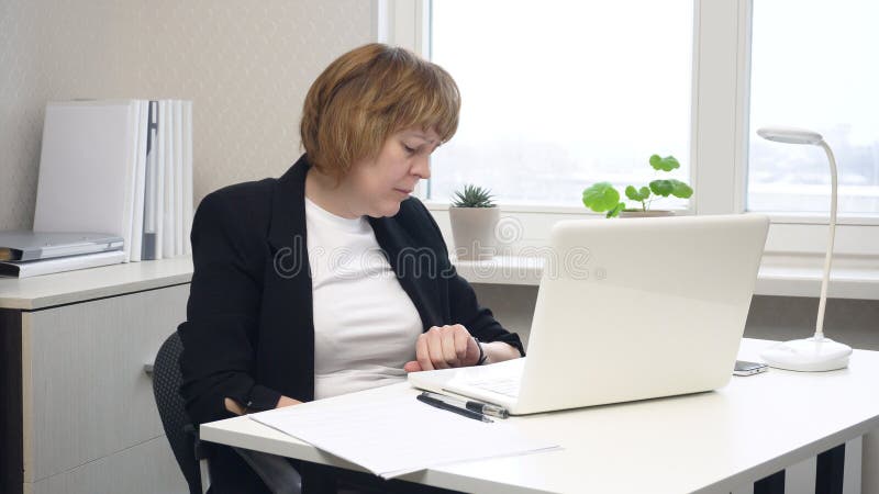 Female Office Worker Looking Tiredly at Clock Stock Image - Image of ...