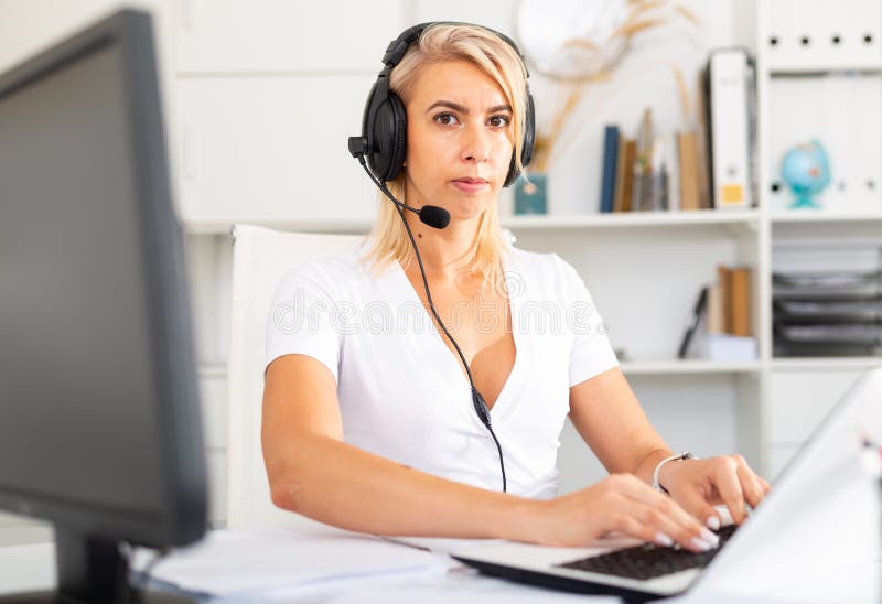Female Operator Talking with Customer Using Headset at Company Office ...