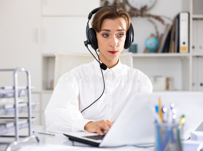 Female Operator Talking with Customer Using Headset at Company Office ...