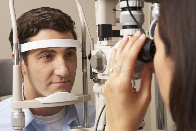 Female Optician in Surgery Giving Man Eye Test Stock Photo - Image of ...