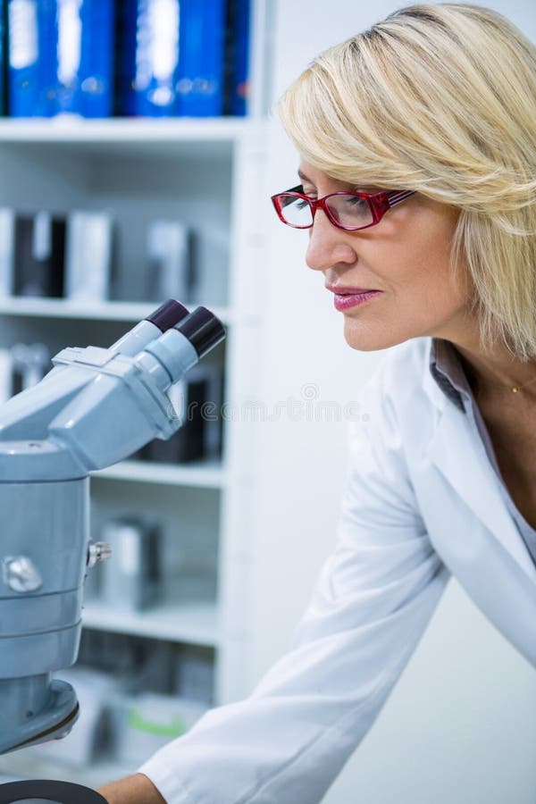 Female Optometrist Looking through Microscope Stock Image - Image of ...
