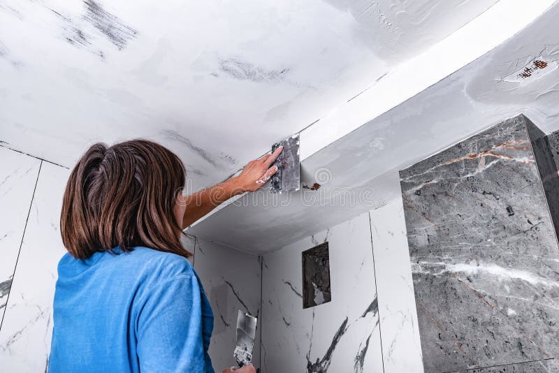 Female Painter Applying Putty To Ceiling. Stock Photo - Image of ...