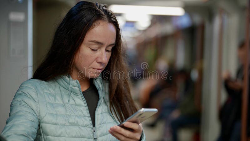 Female Passenger in Train of Subway is Using Smartphone, Surfing ...
