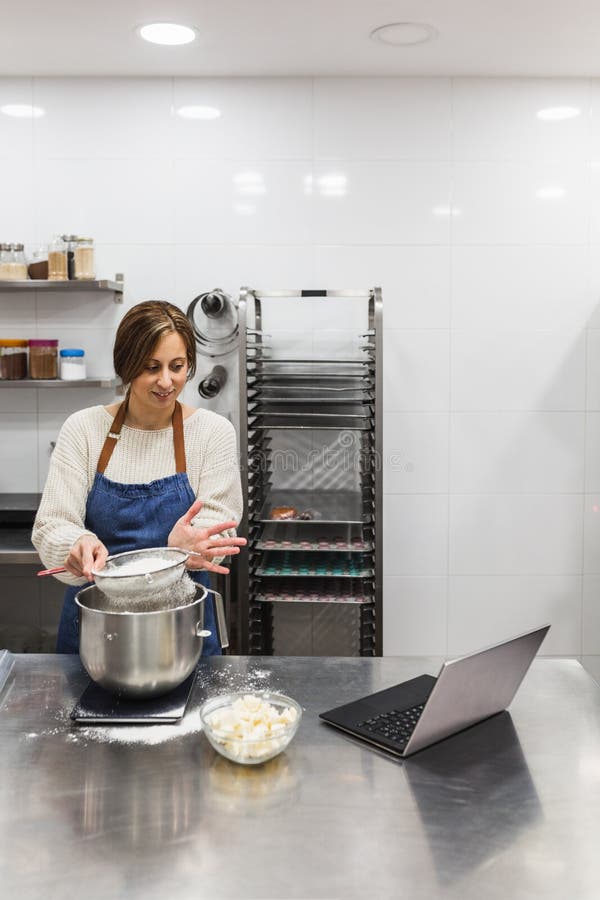 Female Pastry Chef Using a Laptop Computer while Making Tasty Baking in ...