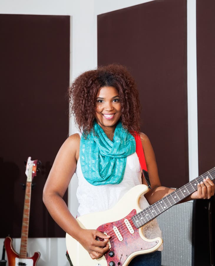 Female Performer Playing Guitar in Studio Stock Image - Image of garage ...