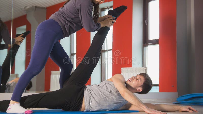 Female Personal Trainer Help Man with Stretching Exercise in Front of ...