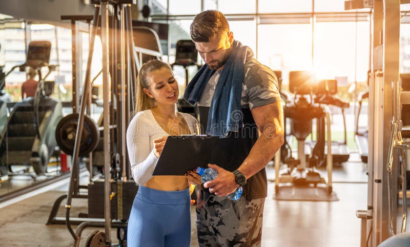 Female Personal Trainer Showing Exercise Progress To Male Client in the ...
