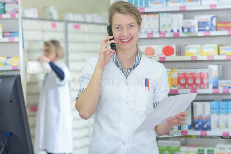 Female Pharmacist on Phone Call Reaching Medication Stock Photo - Image ...