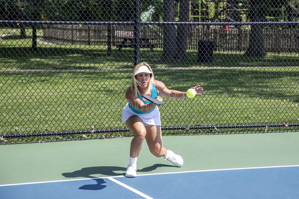 Female Pickleball Player Returns Ball at Baseline Stock Image - Image ...