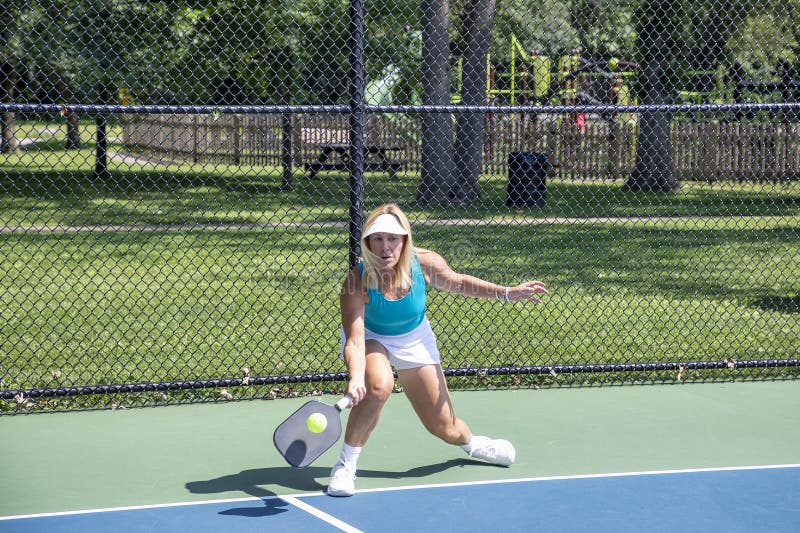 Female Pickleball Player Returns Ball at Baseline Stock Photo - Image ...