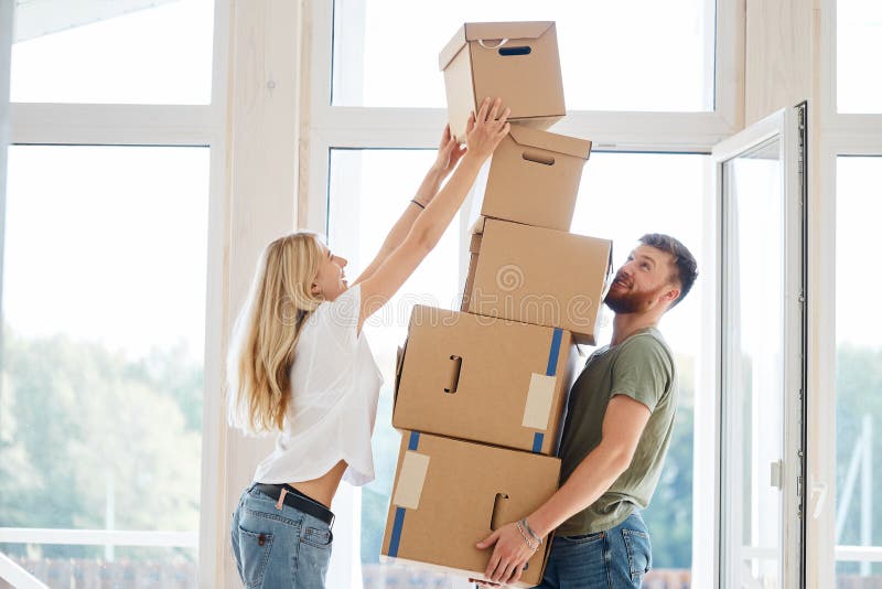 Female Placing Moving Boxes on Large Stack Man is Holding All Stock ...