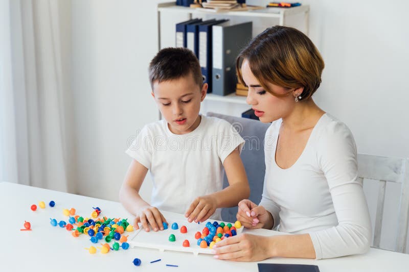 Female Playing Educational Games with Boy at Table in Classroom Stock ...