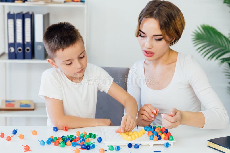 Female Playing Educational Games with Boy at Table in Classroom Stock ...