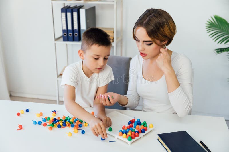 Female Playing Educational Games with Boy at Table in Classroom Stock ...