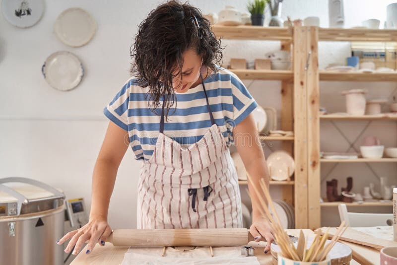 Female Potter in Apron Rolling Clay Slab in a Pottery Workshop. Stock ...