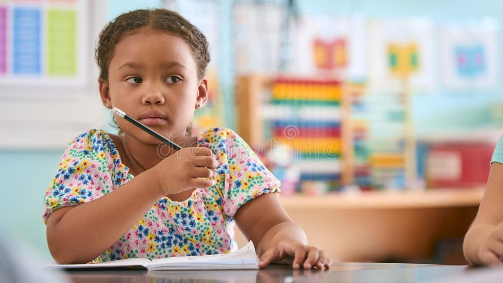 Female Primary or Elementary School Student at Desk in Classroom Stock ...