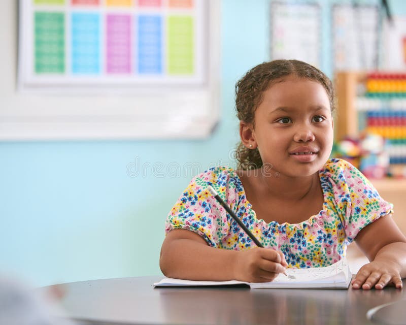 Female Primary or Elementary School Student at Desk in Classroom Stock ...