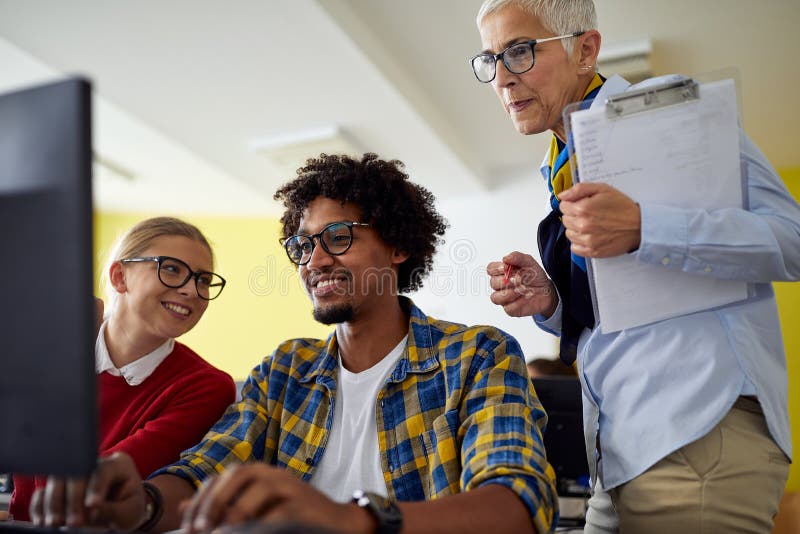 Female Professor Checking Student`s Work at the Informatics Lecture ...