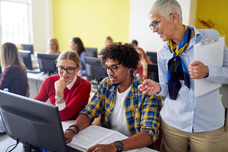 A Female Professor Checking Work of Students at the Informatics Lecture ...