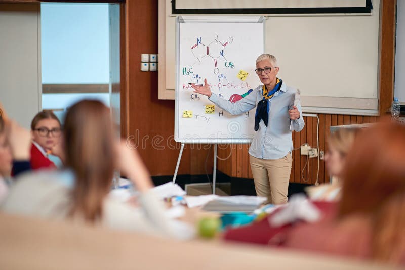 Female Professor Giving Lecture Stock Photo - Image of books, focused ...
