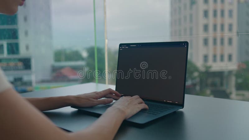 A Female Programmer Works on a Laptop Overlooking a Rainy City Stock ...