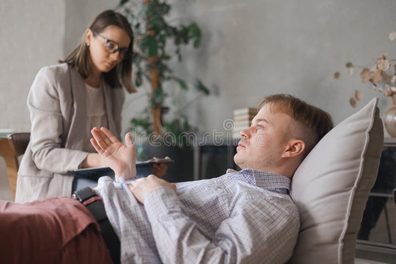 Female Psychologist Conducts Psychotherapy Session For Man Stock Image