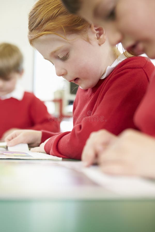 Female Pupil Reading Book at Table Stock Photo - Image of lesson ...