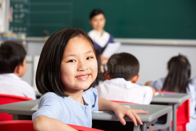 Female Pupil Working at Desk in Chinese School Stock Image - Image of ...