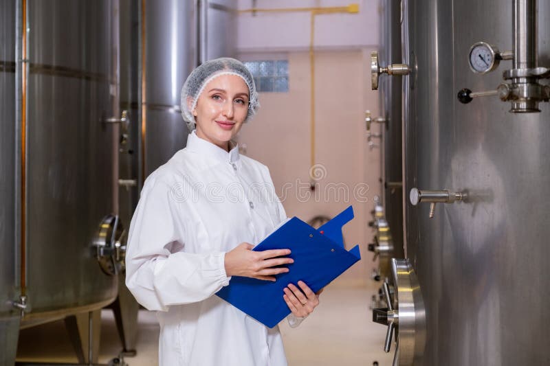 Female Quality Control Inspector Smiling while Checking Wine Tanks in a ...