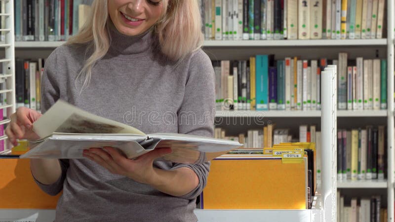Female Reader Turning Over Pages of a Book while Reading at Library ...