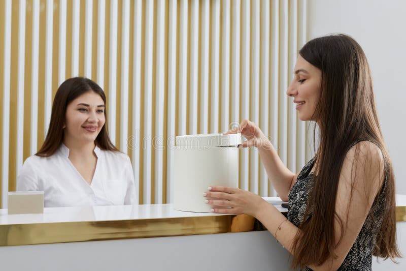 Female Receptionist at Reception Desk with a Client in a Modern Office ...