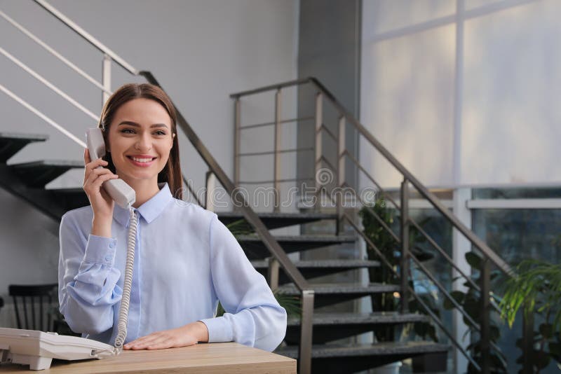 Female Receptionist Talking on Phone at Workplace. Space for Text Stock ...