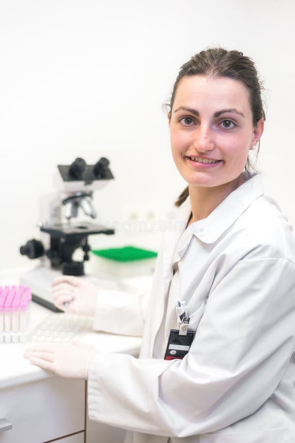 Female Researcher Smiling. Female Researcher Using Microscope and ...