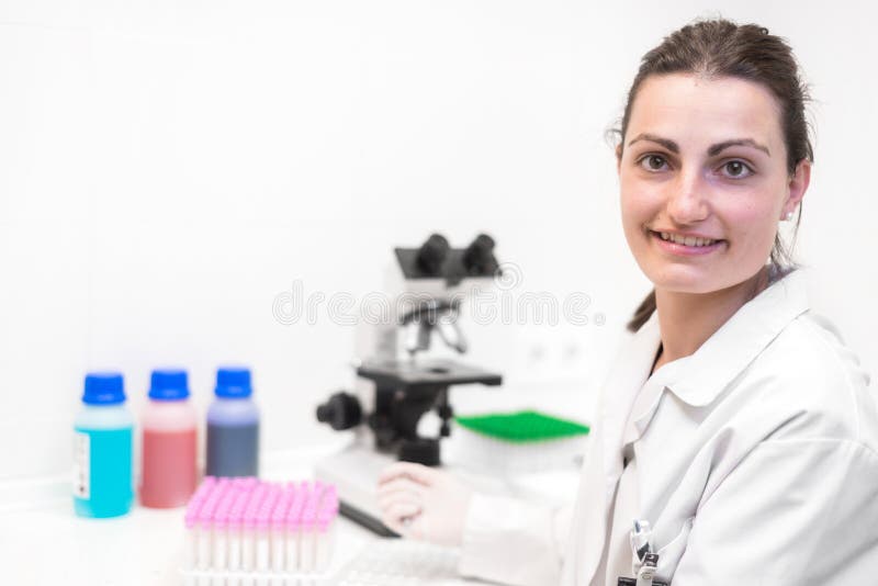 Female Researcher Smiling. Female Researcher Using Microscope and ...
