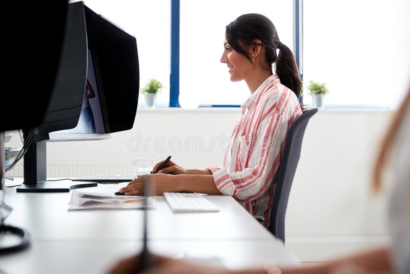 Two Female Retouchers Working at Computer Using Graphics Tablet in Post ...