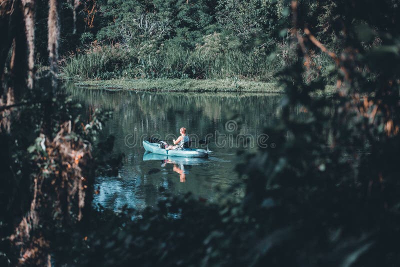 Female Riding a Boat in a Lake with the Reflection of the Forest Stock ...