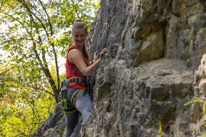 Female Rock Climber Scaling a Challenging Rock Face of a Mountain Stock ...
