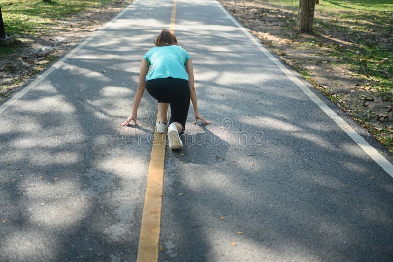 Female Runner Crouches into the Starting Position for Sprint on Running ...