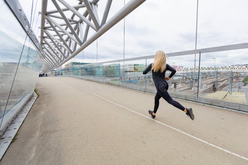 Female Runner during Fast Running Exercise in Modern City at Cloudy Day ...