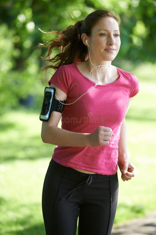 Female Runner in Park with Wearable Technology Stock Photo - Image of ...