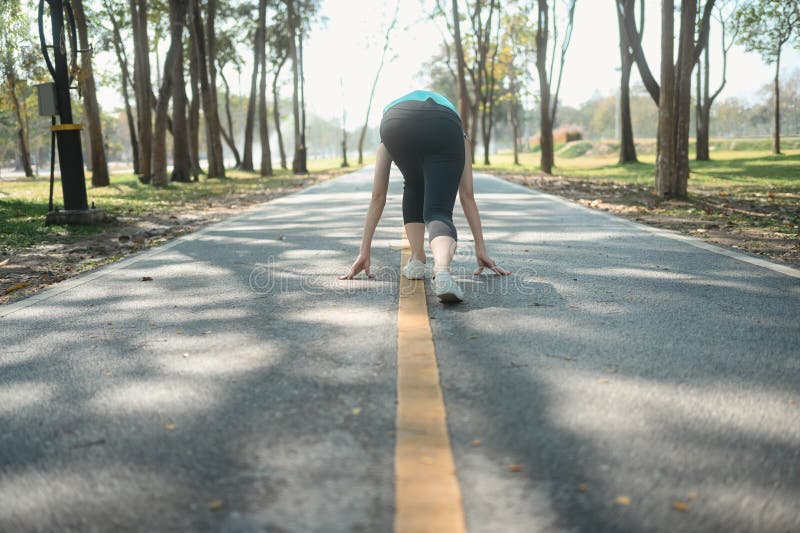 Female Runner in a Starting Position on a Road. Goals and Motivation ...