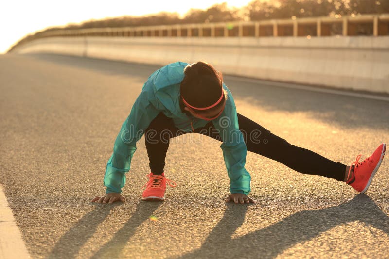 Female Runner Stretching Her Legs on Sunrise Road Stock Image - Image ...