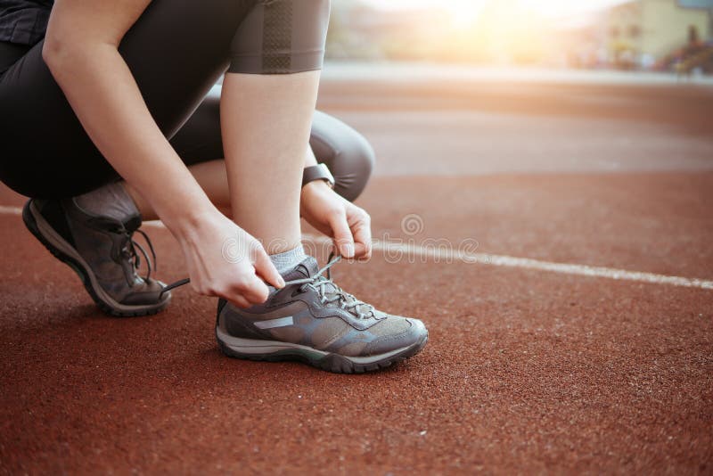 Female Runner Tying Shoe Lace in a Stadium Area. Stock Photo - Image of ...