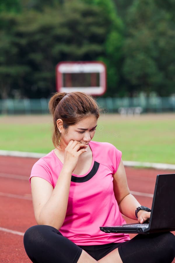 Female Runner Using Laptop Computer on the Running Track Stock Photo ...